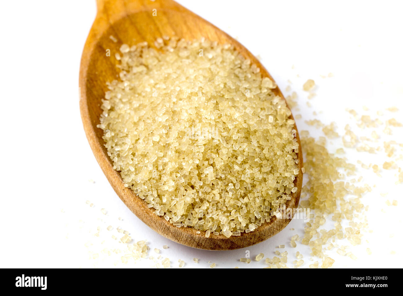 wooden scoop spoon of brown cane sugar with pinch of sugar spilled ...