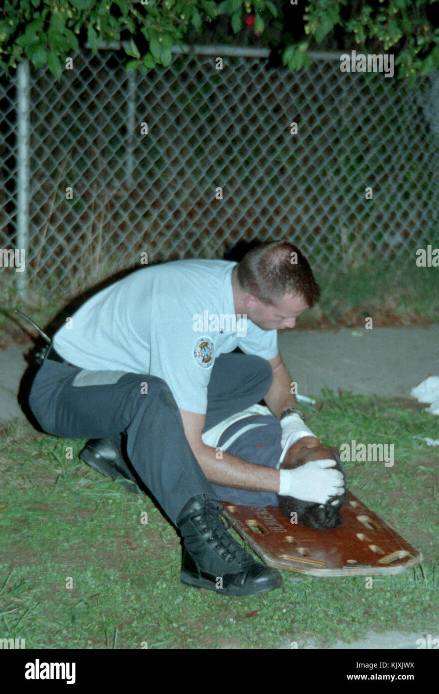 rescuer works on a injured child that was injured in a auto accident ...