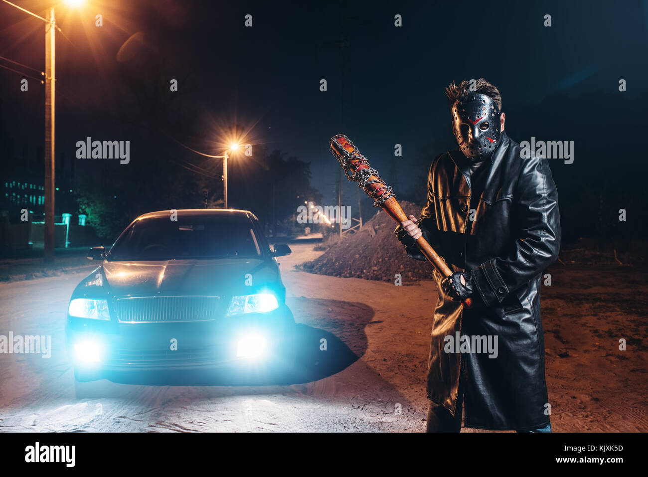 Serial maniac in leather coat and hockey mask, bloody baseball bat ...