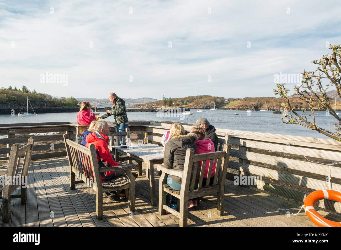 customers enjoying the sun terrace in spring at Badachro Inn, Badachro ...