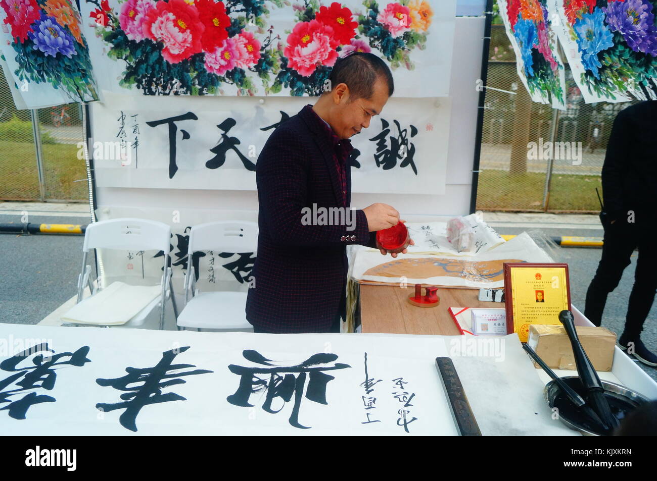 A Chinese calligraphy artist is selling his own calligraphy paintings ...