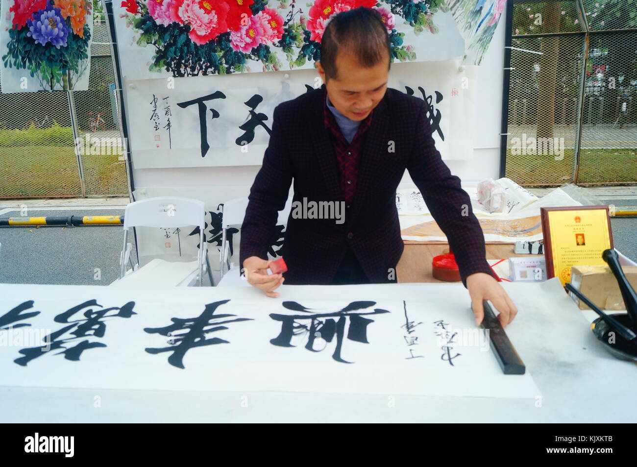 A Chinese calligraphy artist is selling his own calligraphy paintings ...