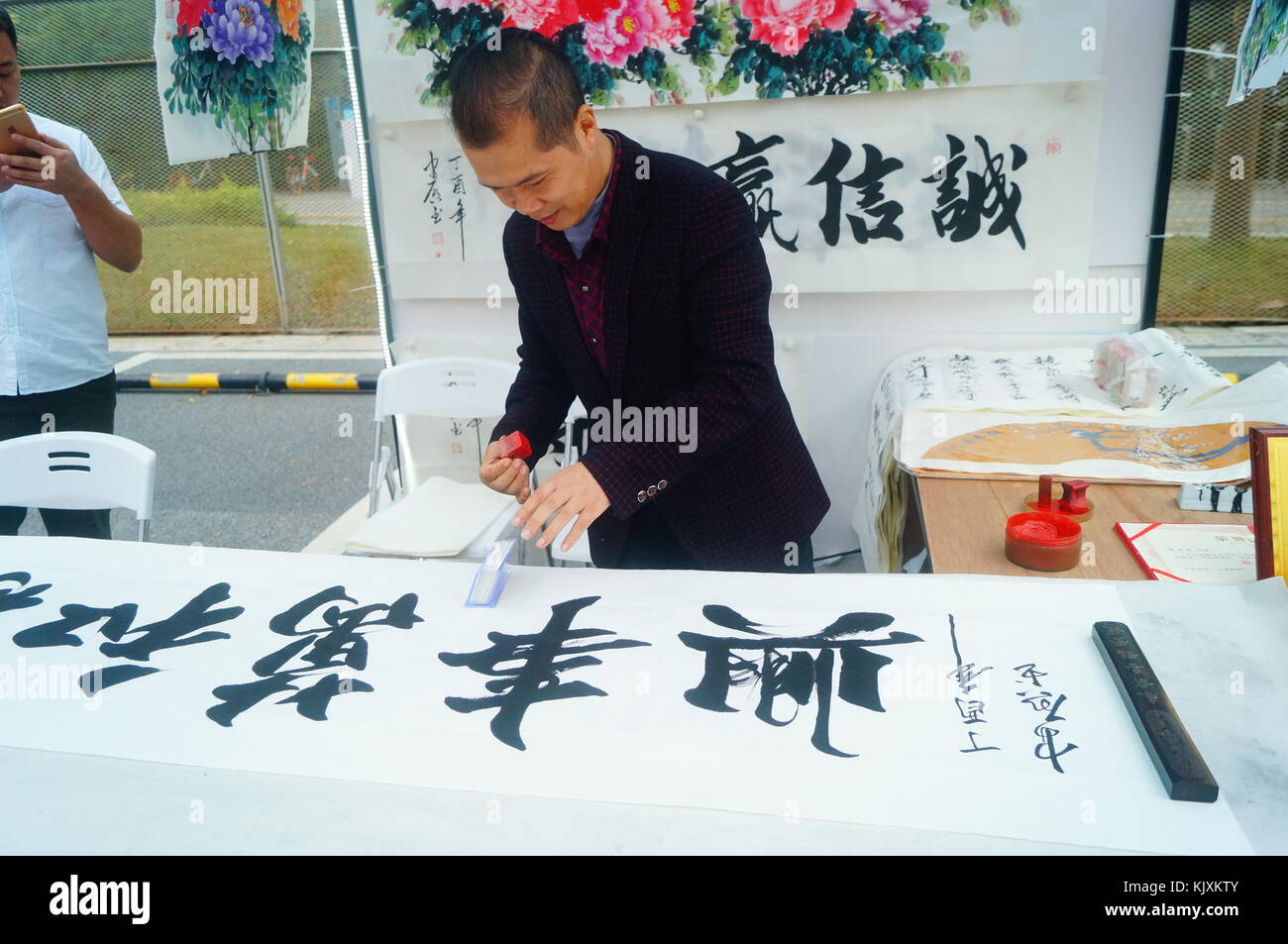 A Chinese calligraphy artist is selling his own calligraphy paintings ...