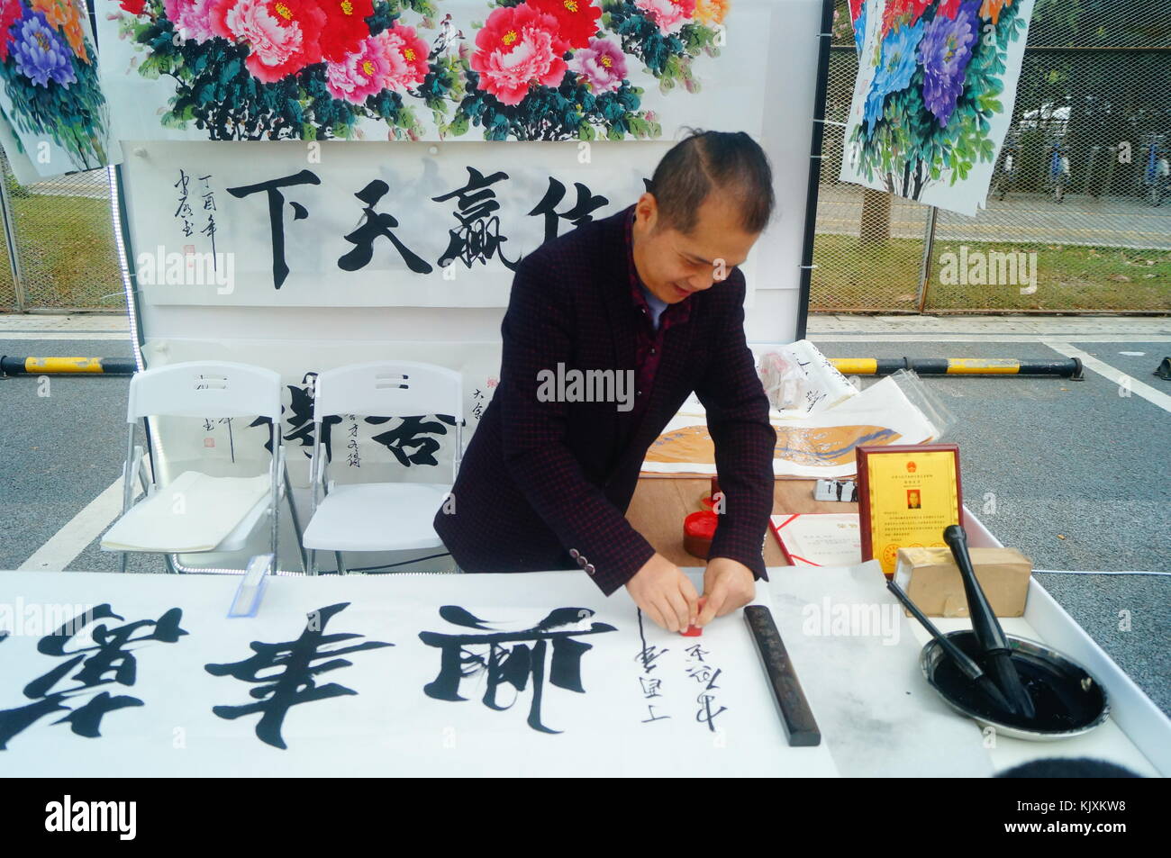 A Chinese calligraphy artist is selling his own calligraphy paintings ...