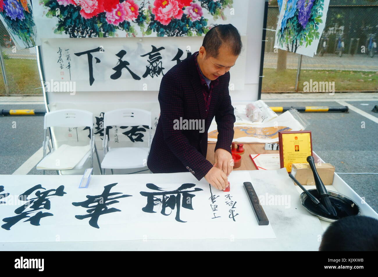 A Chinese calligraphy artist is selling his own calligraphy paintings ...