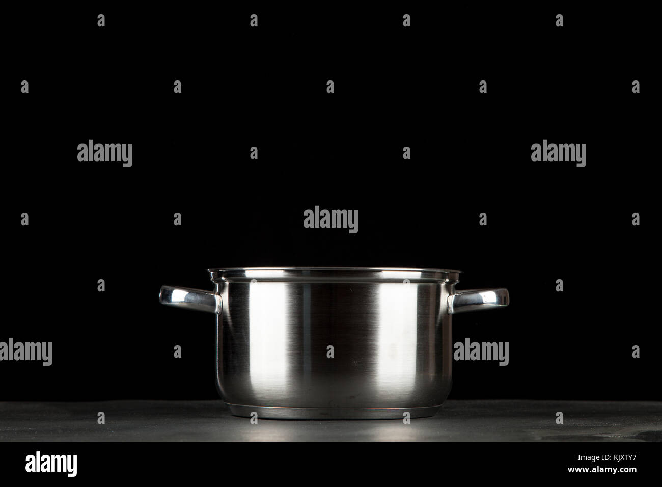 Metal pot on black background Stock Photo - Alamy