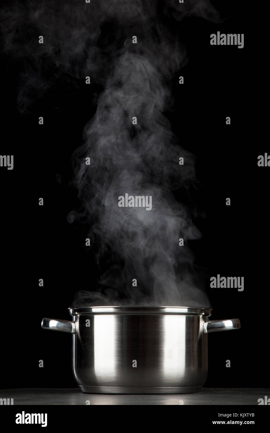 Steaming pot on black background Stock Photo - Alamy