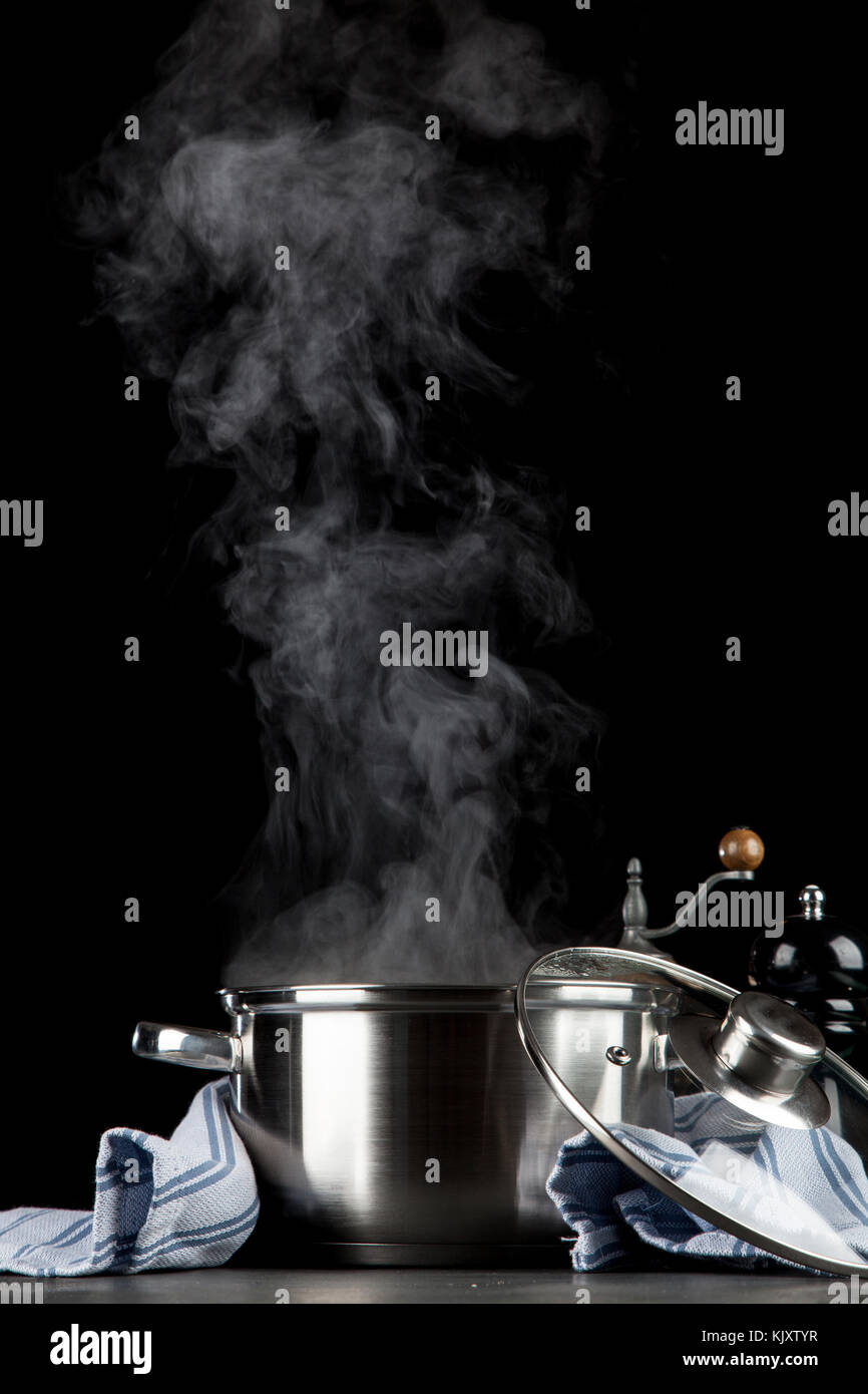 Steaming pot on black background Stock Photo - Alamy