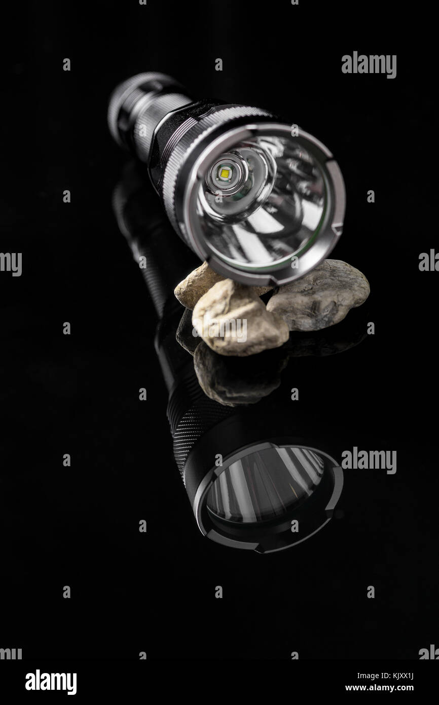 Flashlight LED on stones mirroring on black background. Useful for ...