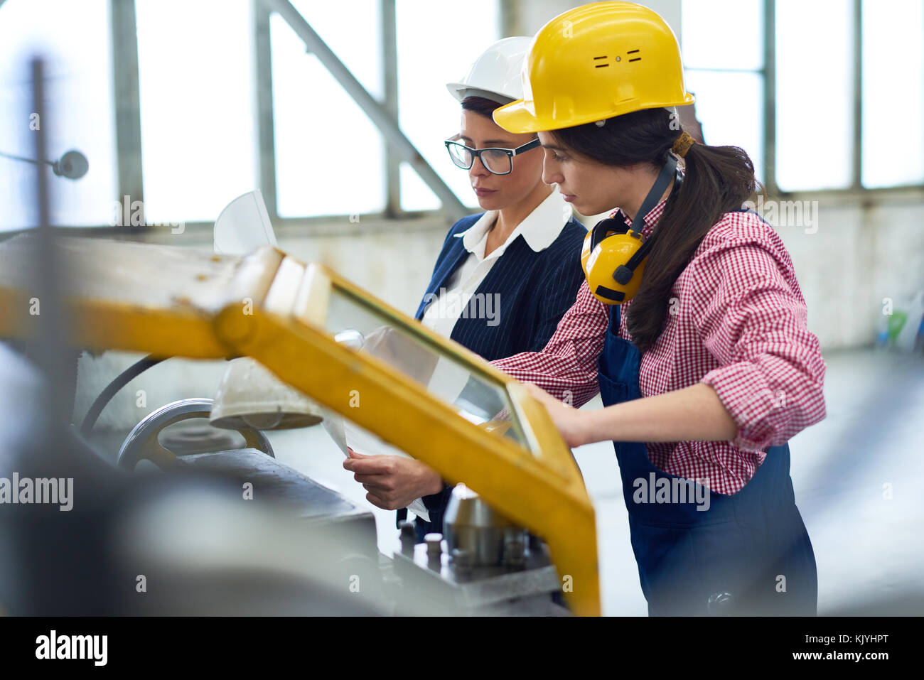Thoughtful busy factory employees working as team and analyzing ...