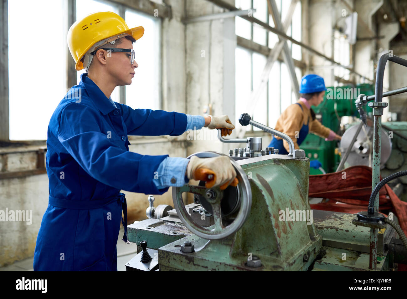 Concentrated confident engineer working on tailstock and rolling wheel ...