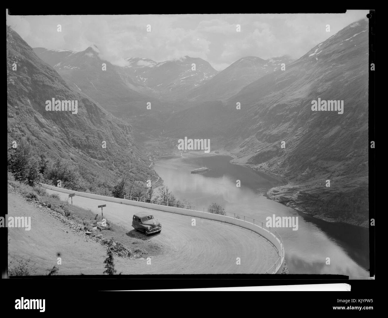 A scenic photograph of Geiranger, featuring a fjord, mountains, and a ...
