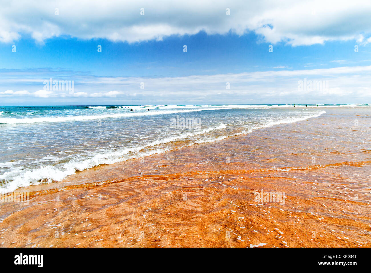 Shallow water on the sandy sea beach. Appears through sand, in the ...
