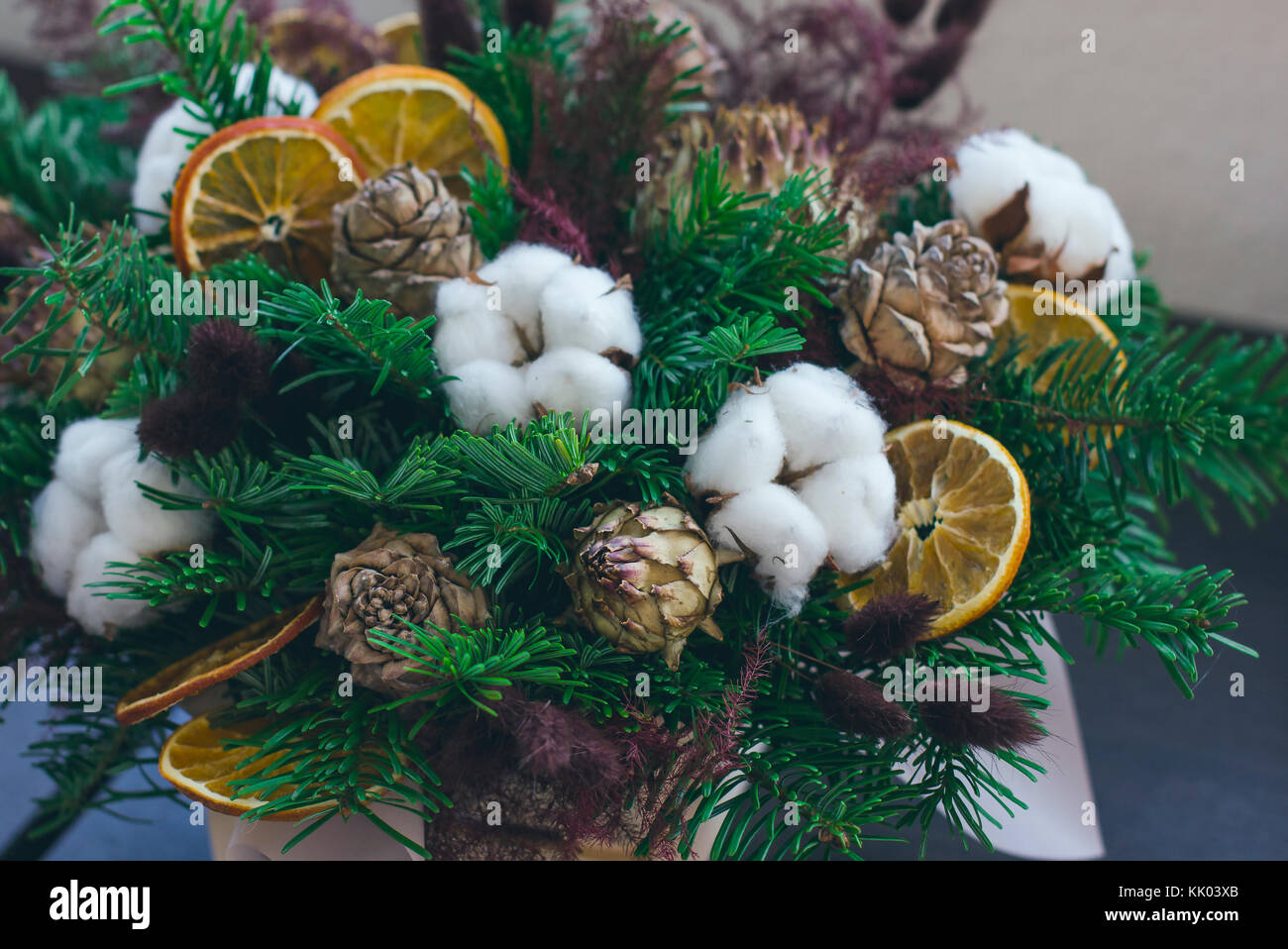 The winter composition of fir branches, dry oranges, cotton and cones ...