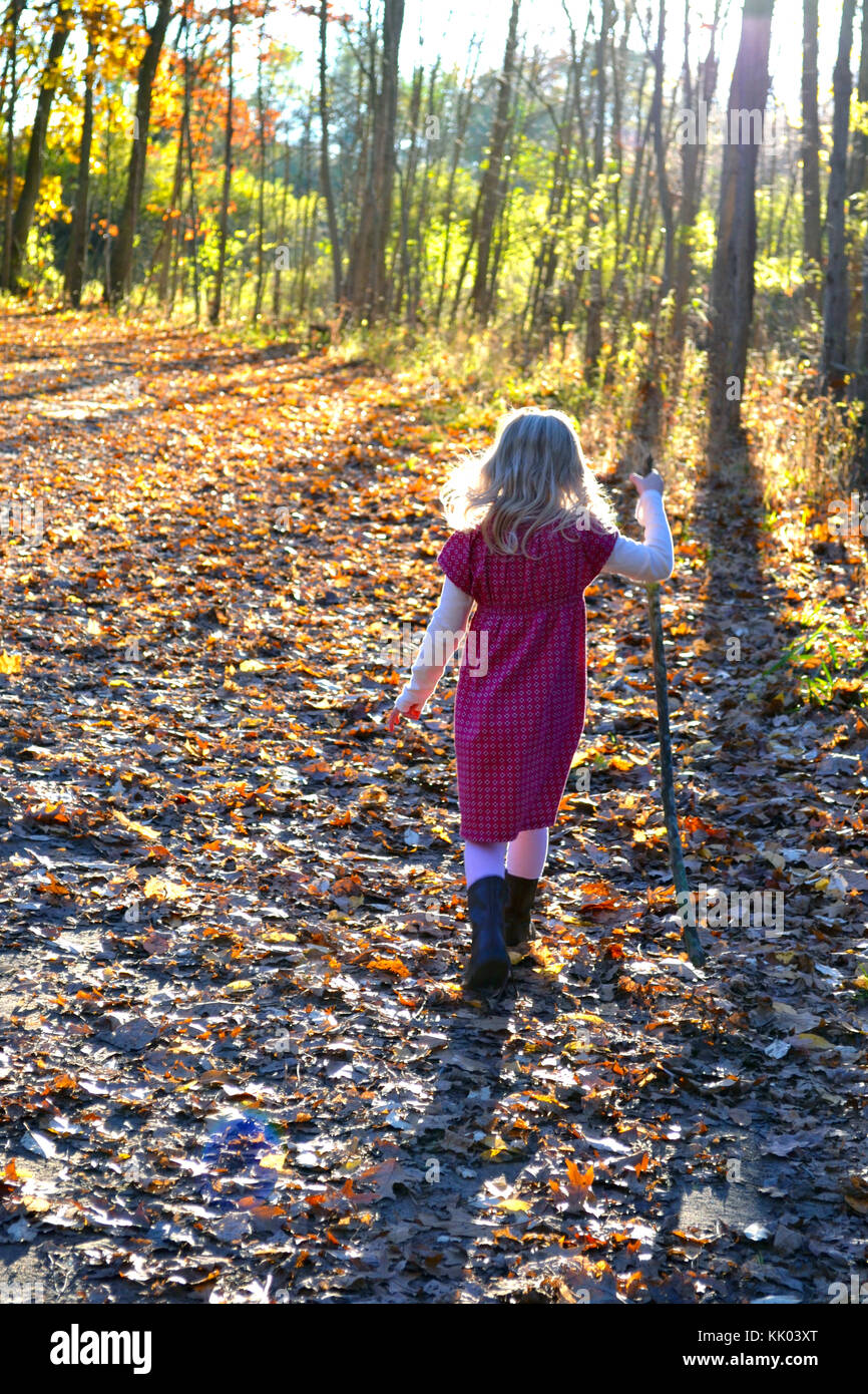 Young girl walking through the park Stock Photo - Alamy
