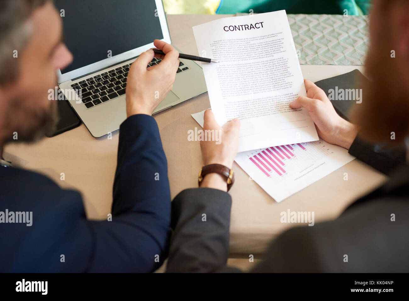 Over shoulder view of unrecognizable business partners sitting at ...