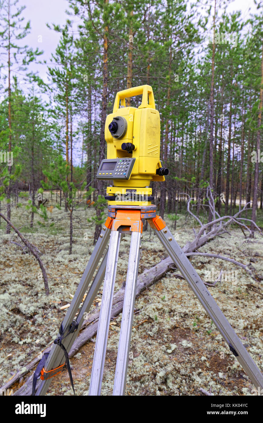Modern threadbare electronic total station mounted on tripod in field ...