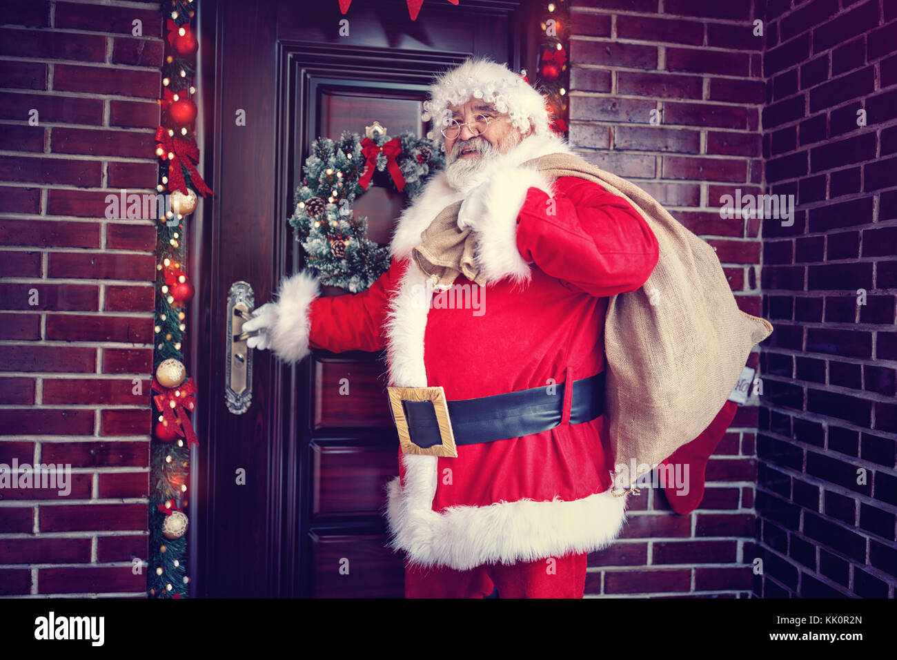 Joyous coming Santa Claus with gifts in home for Christmas Stock Photo ...
