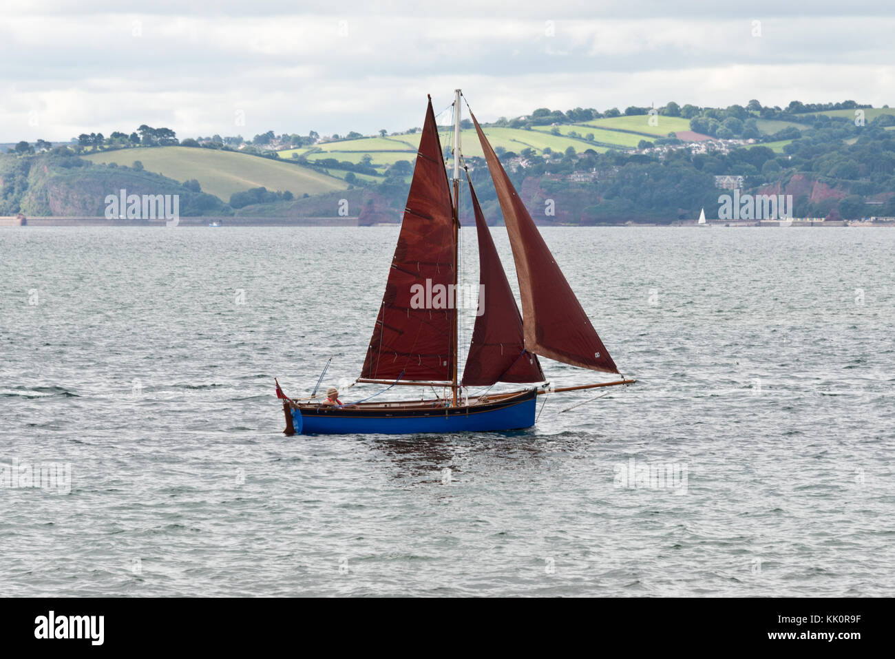 A lone yachtsman sailing into the entrance of the River Exe at Exmouth ...
