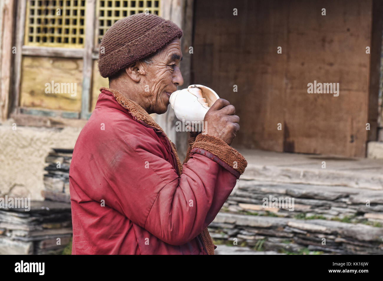 Monk blows his conch shell as a call to puja, Tsum Valley, Nepal Stock ...