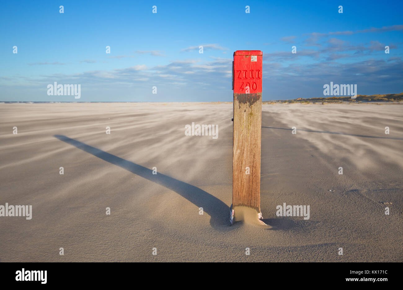 Red beach pole on a vast, stormy beach Stock Photo - Alamy