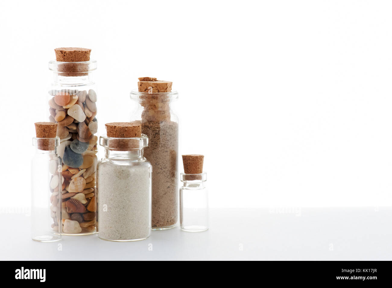 Glass bottles with sand on the white background Stock Photo - Alamy