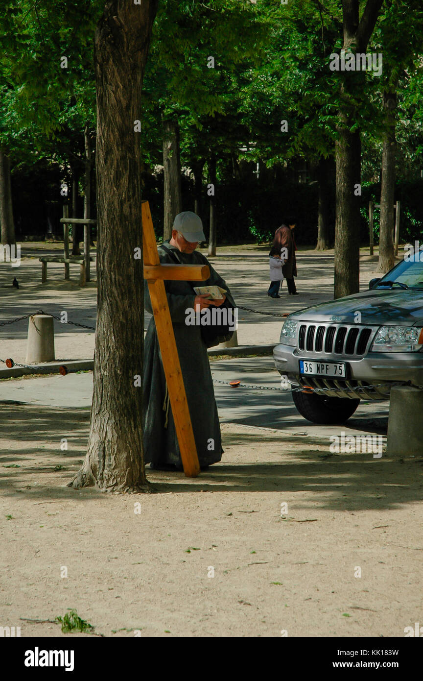 Pilgrim or a priest wearing religious habit walking carrying a cross ...