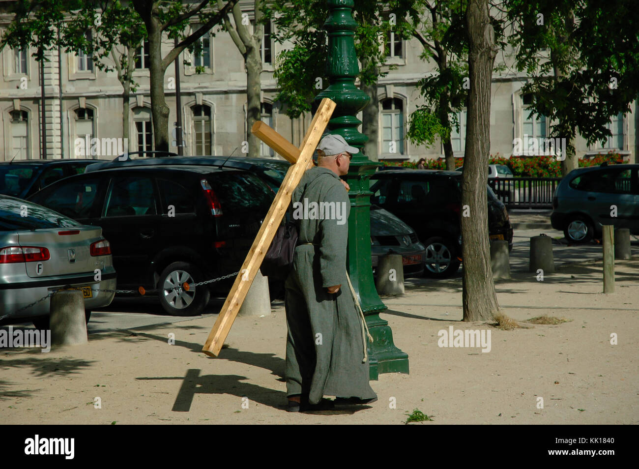 Pilgrim or a priest wearing religious habit walking carrying a cross ...
