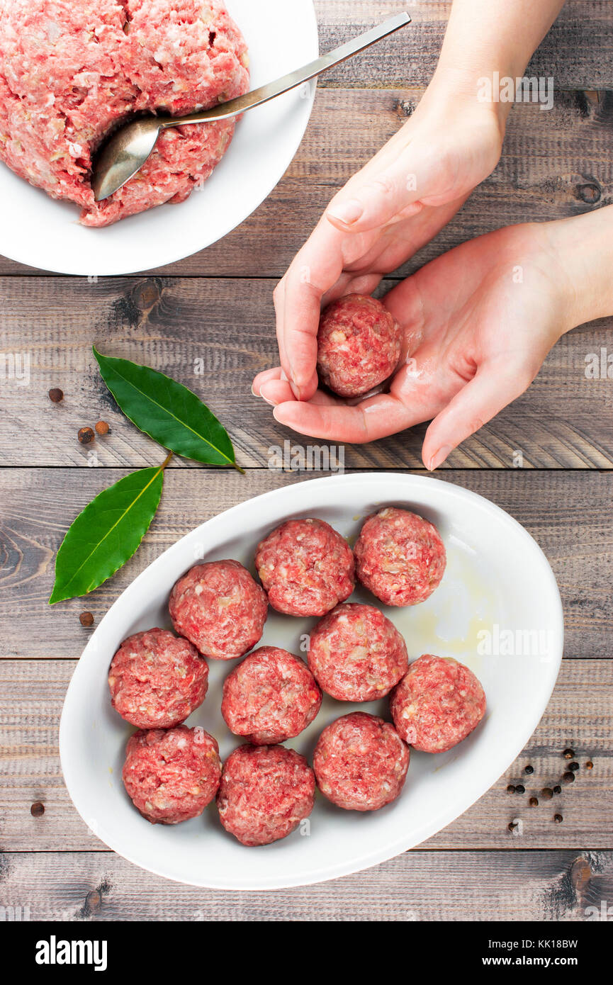 Female hands prepare meatballs on the wooden table, top view Stock ...