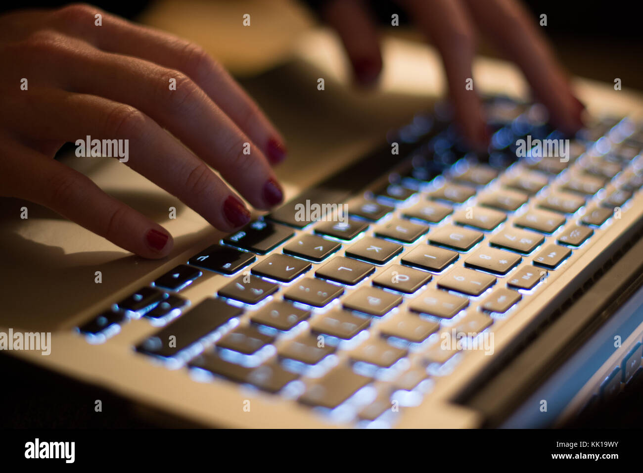 Woman typing on keyboard at night Stock Photo - Alamy