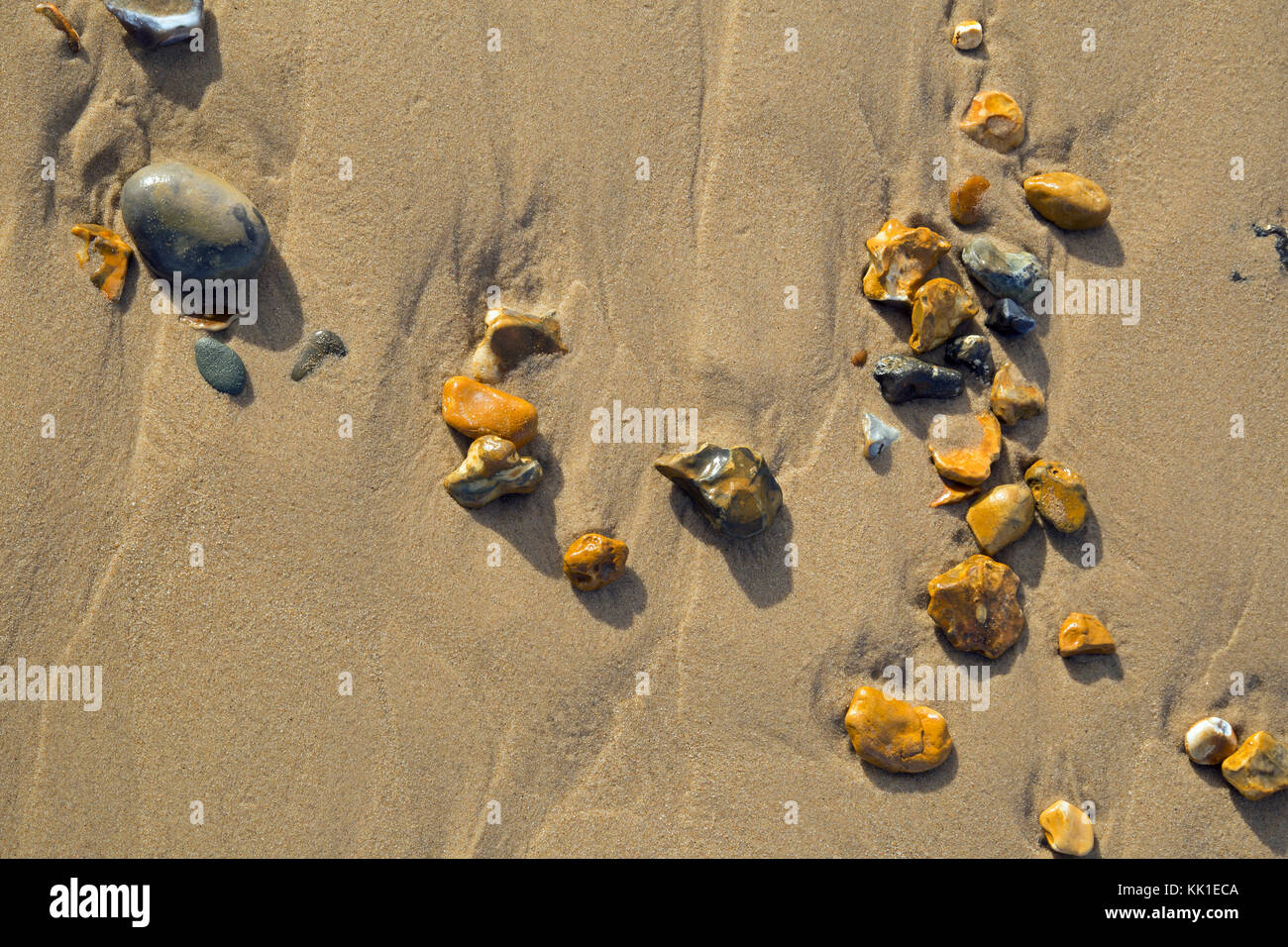 Pebbles left by the tide on a sandy beach, viewed from above and ...