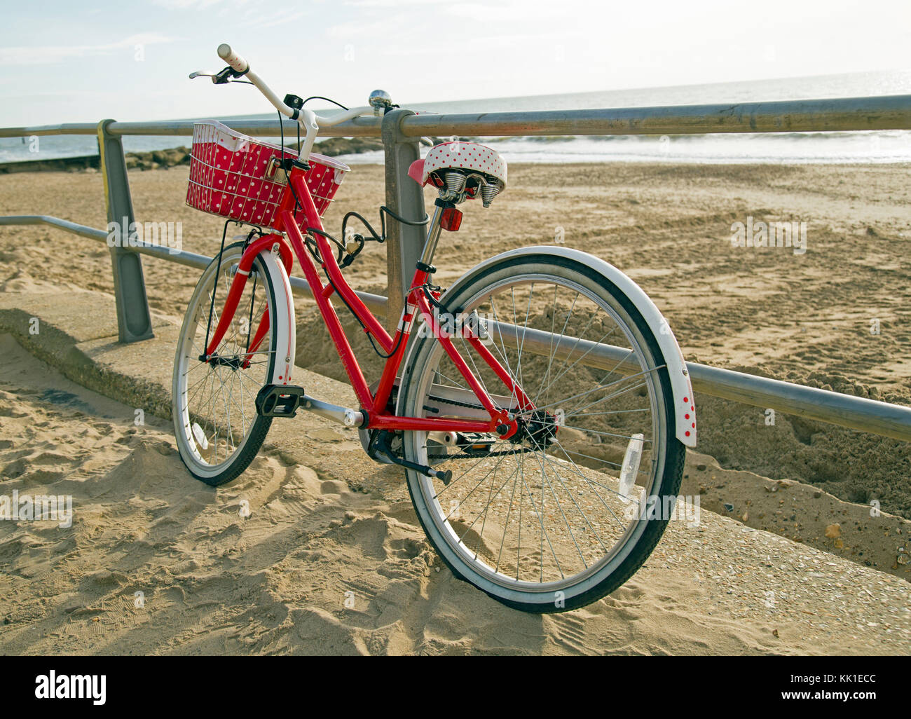 A red bicycle chained to railings at the beach Stock Photo - Alamy