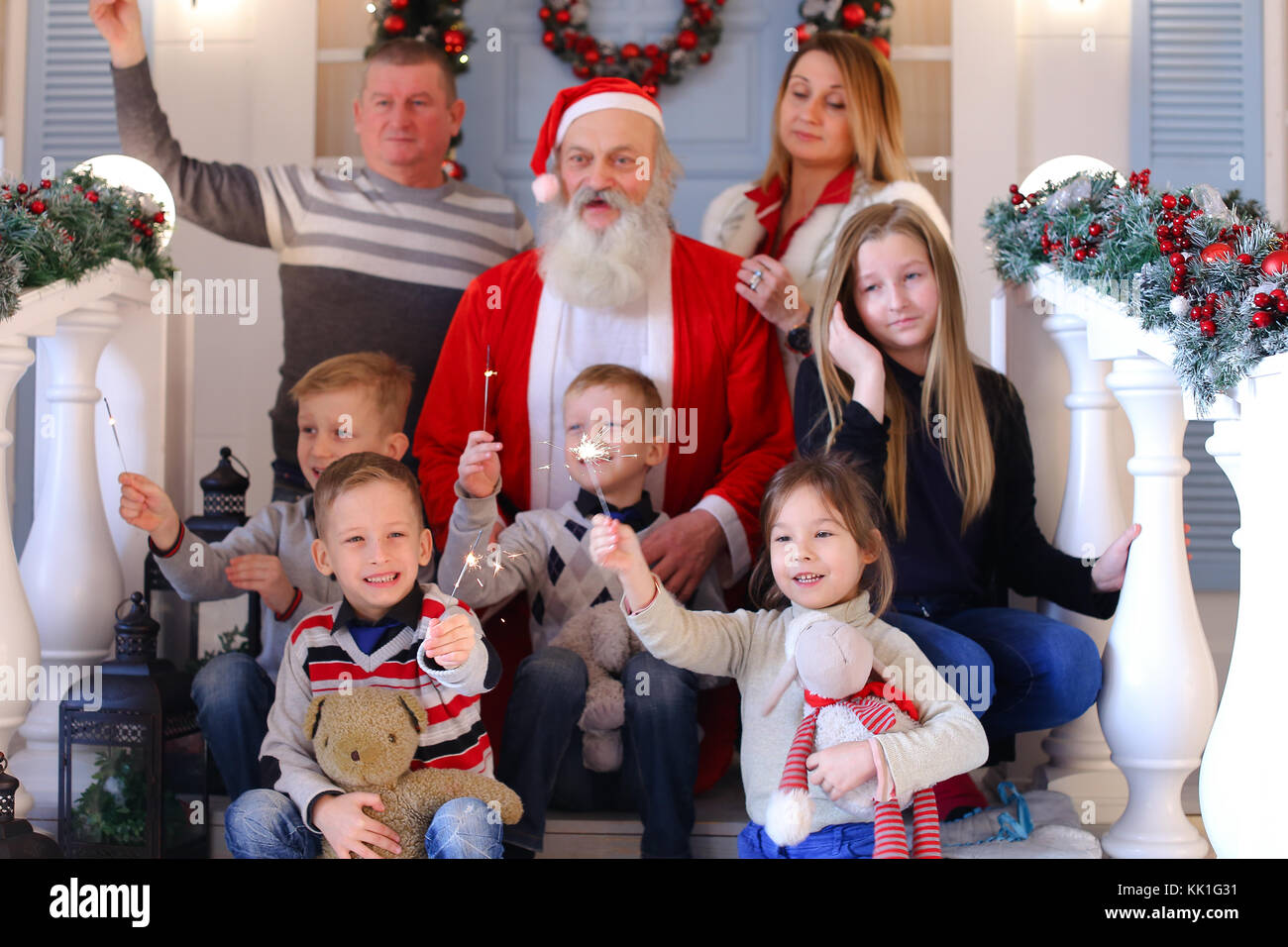Friendly family and Santa Claus posing for camera on porch of ho Stock ...