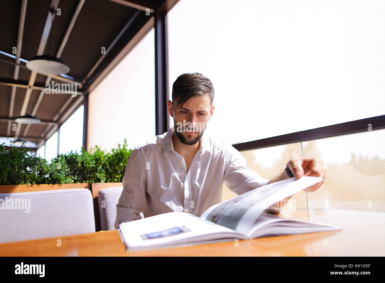 Art director and designer watching new magazine at cafe table Stock ...