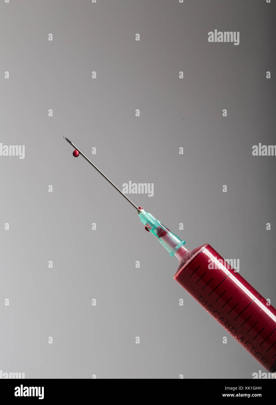 Close up macro view of a syringe / syringes full of coloured fluid ...