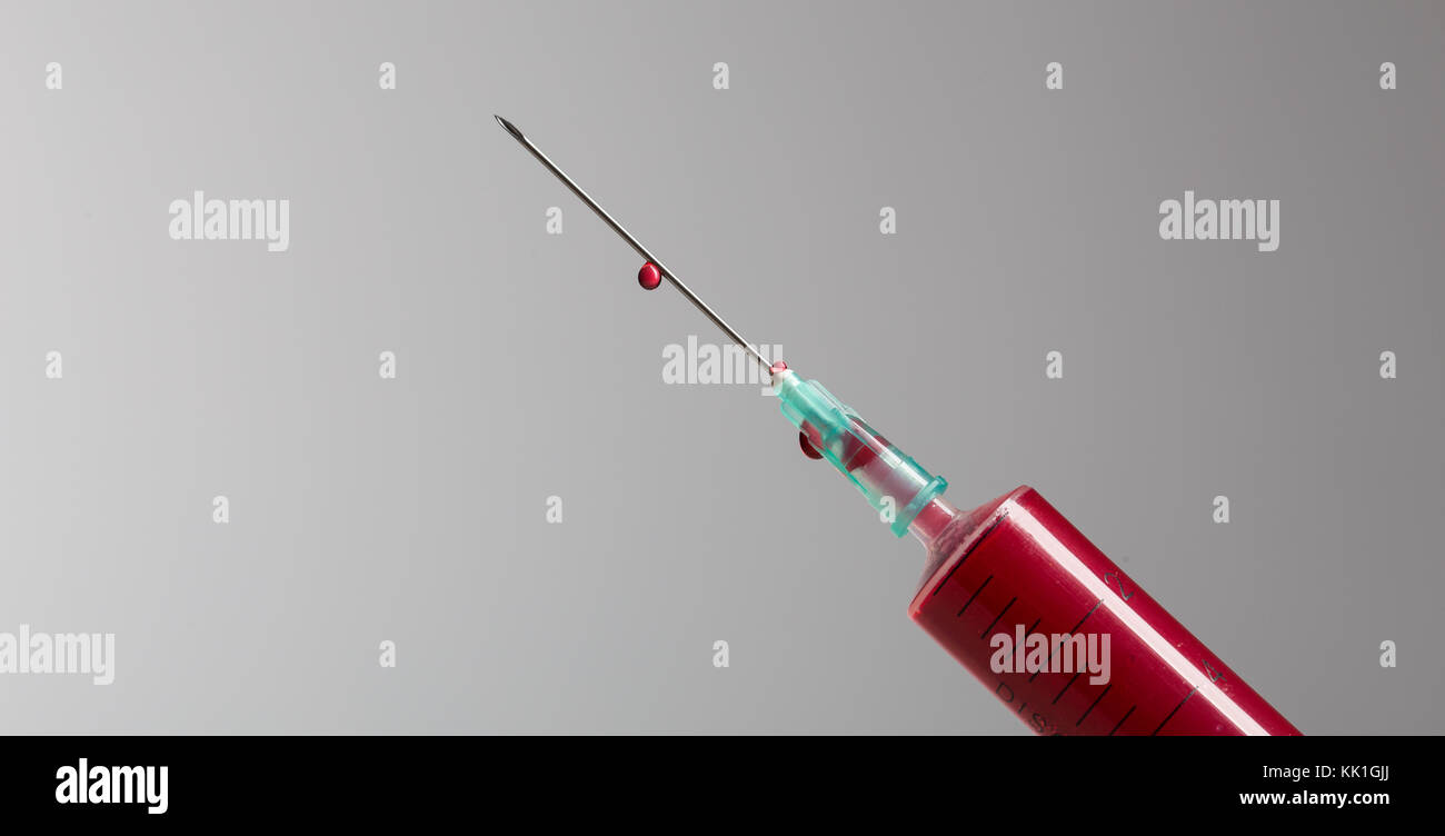 Close up macro view of a syringe / syringes full of coloured fluid ...