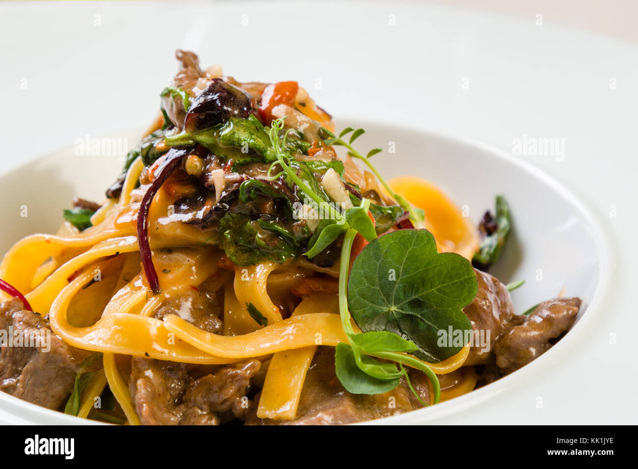 stylish gourmet tasty tagliatelle with beef in white plate Stock Photo ...