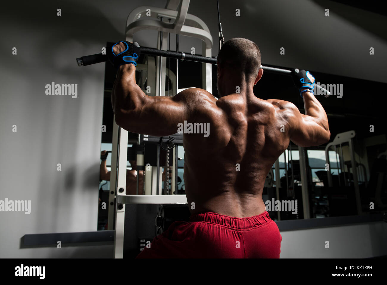Handsome Bodybuilder Doing Heavy Weight Exercise For Back On Machine ...