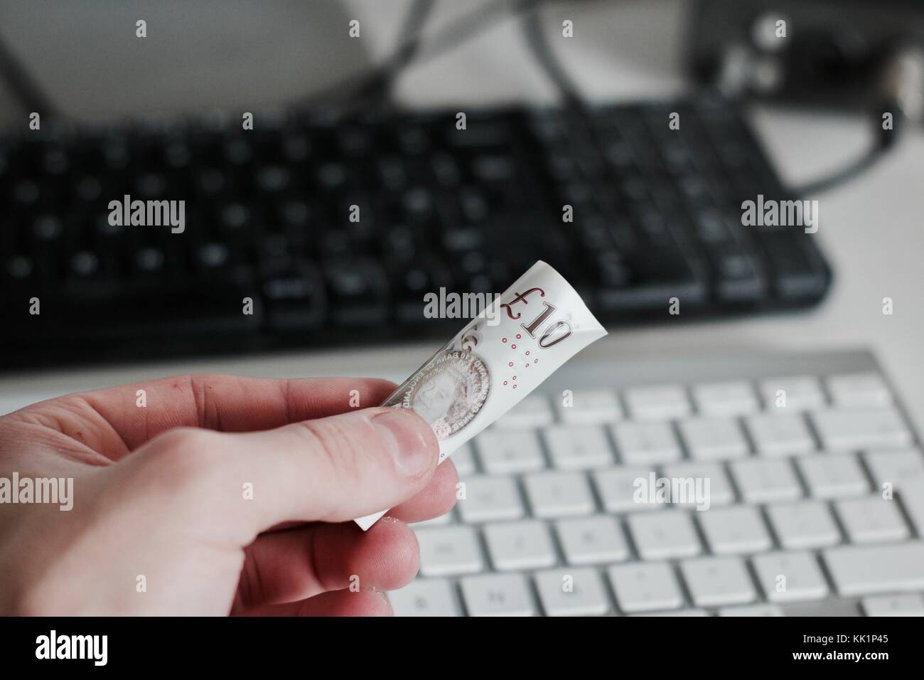 British paper money in hand near white computer keyboard. Money concept ...