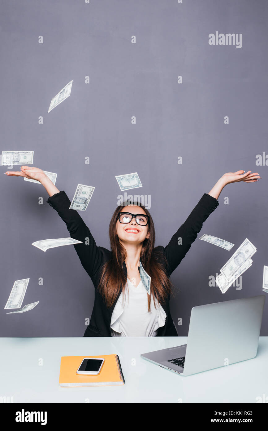 Business woman at her office working place throw the Money flying over ...