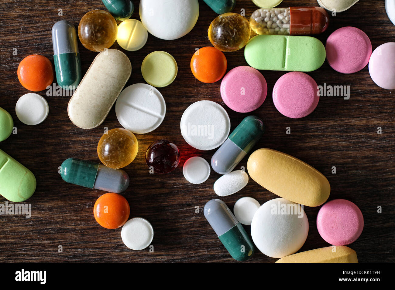 Medical background of various colorful medications on a textured wooden ...