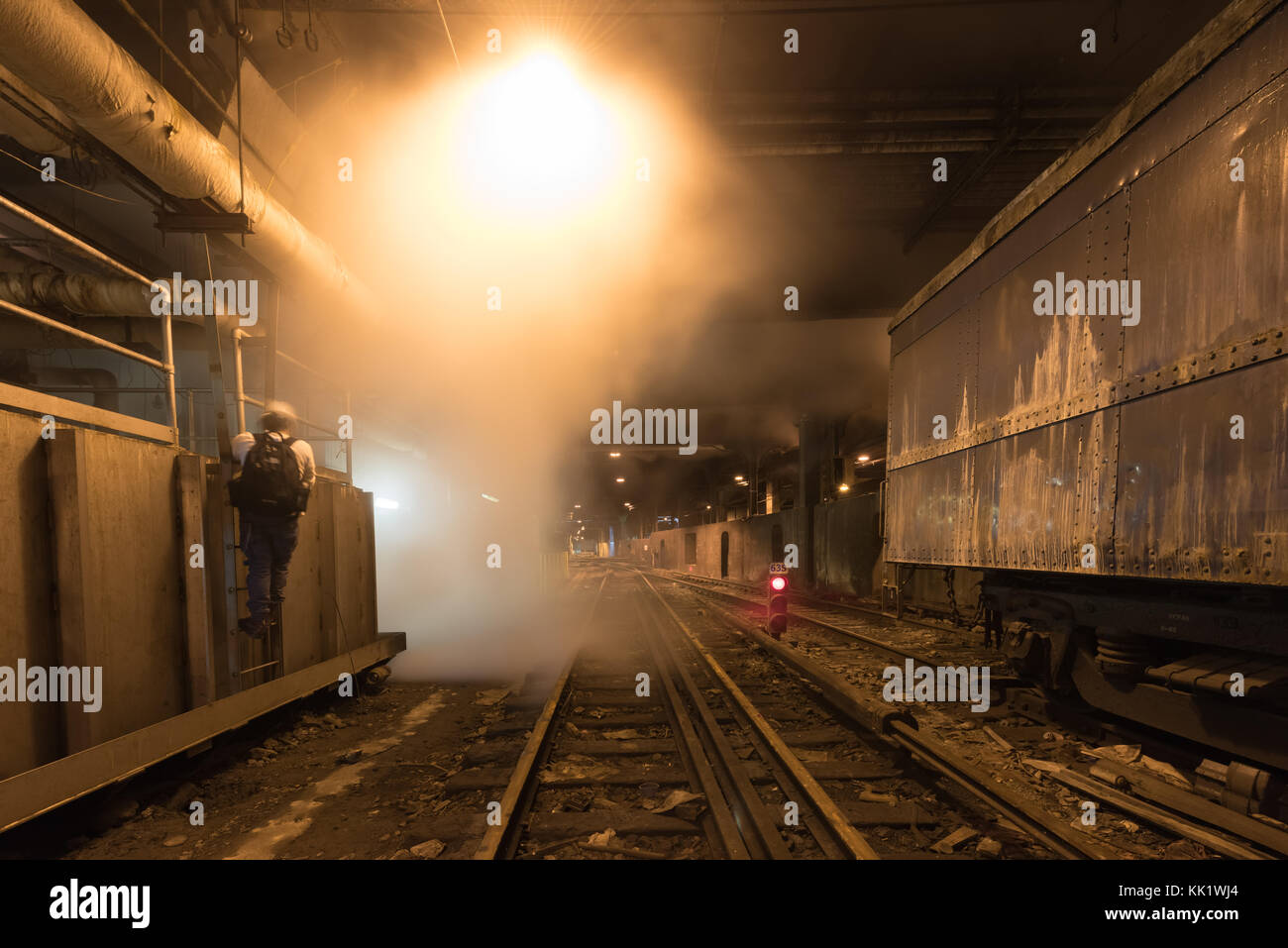 Worker traversing the underground train tracks of Grand Central Station ...