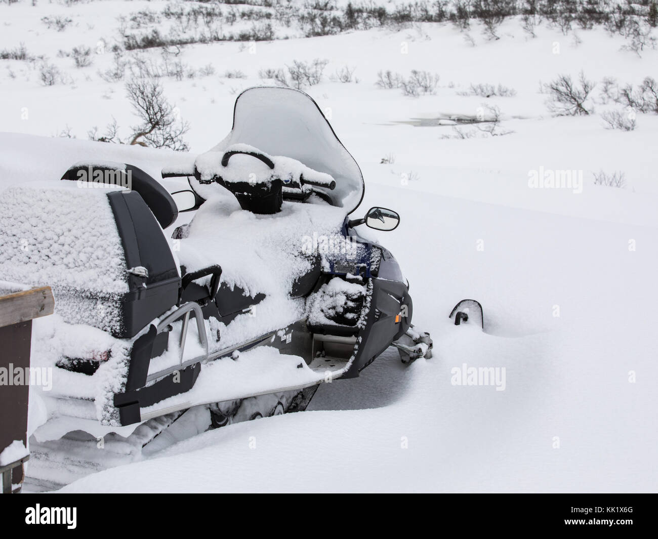 A snow mobile parked outside is covered in snow Stock Photo - Alamy