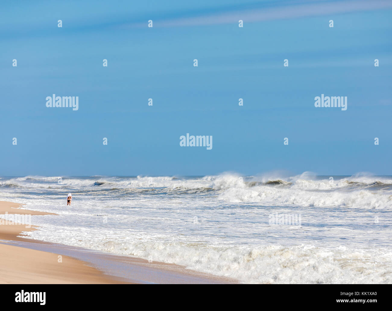 woman standing alone in the surf of an East Hampton ocean beach, east ...