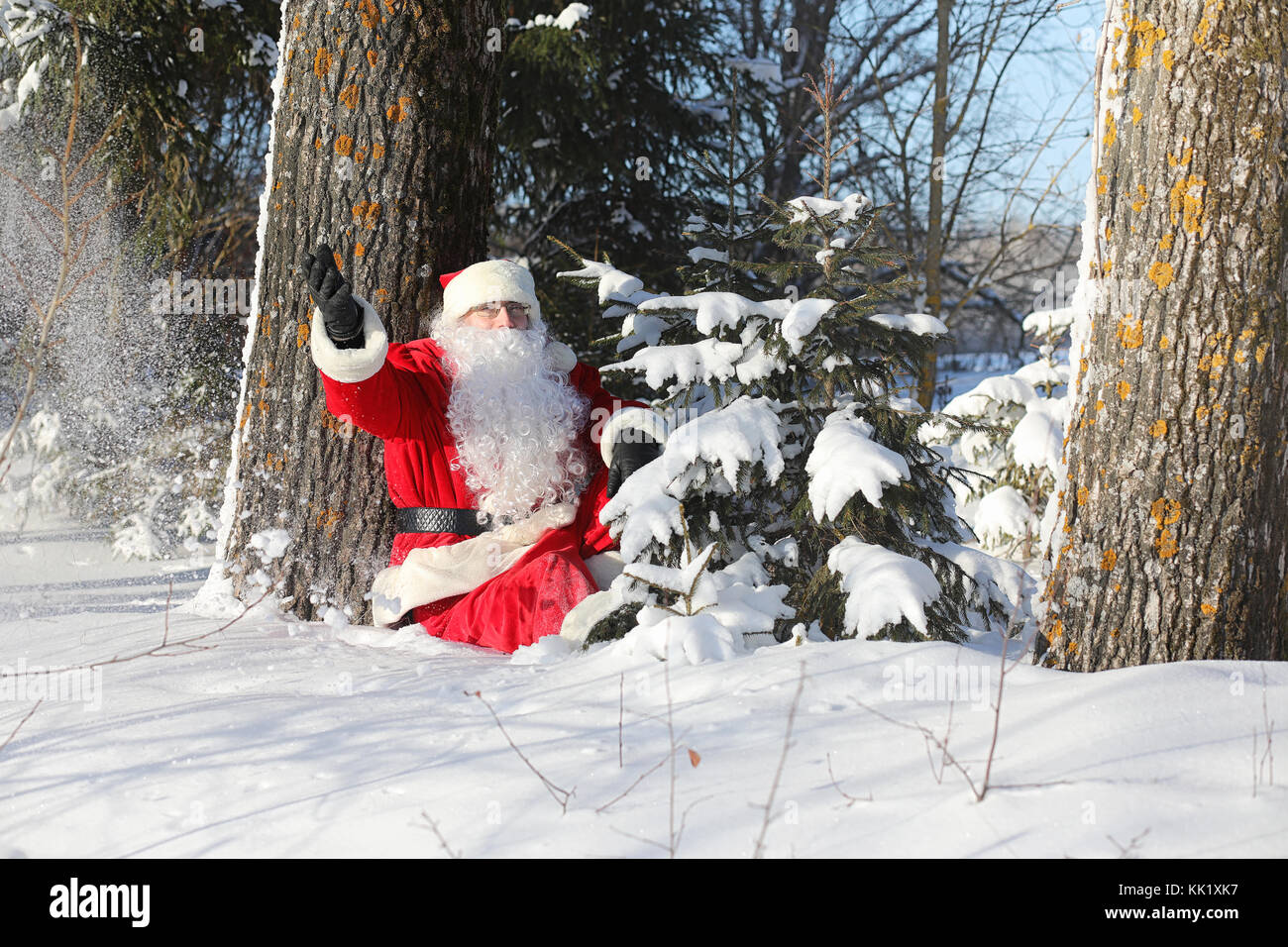 Santa Claus comes with gifts from the outside. Santa in a red su Stock ...