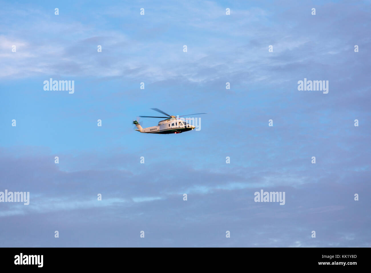 helicopter flying in a beautiful blue sky over the beach in Southampton ...