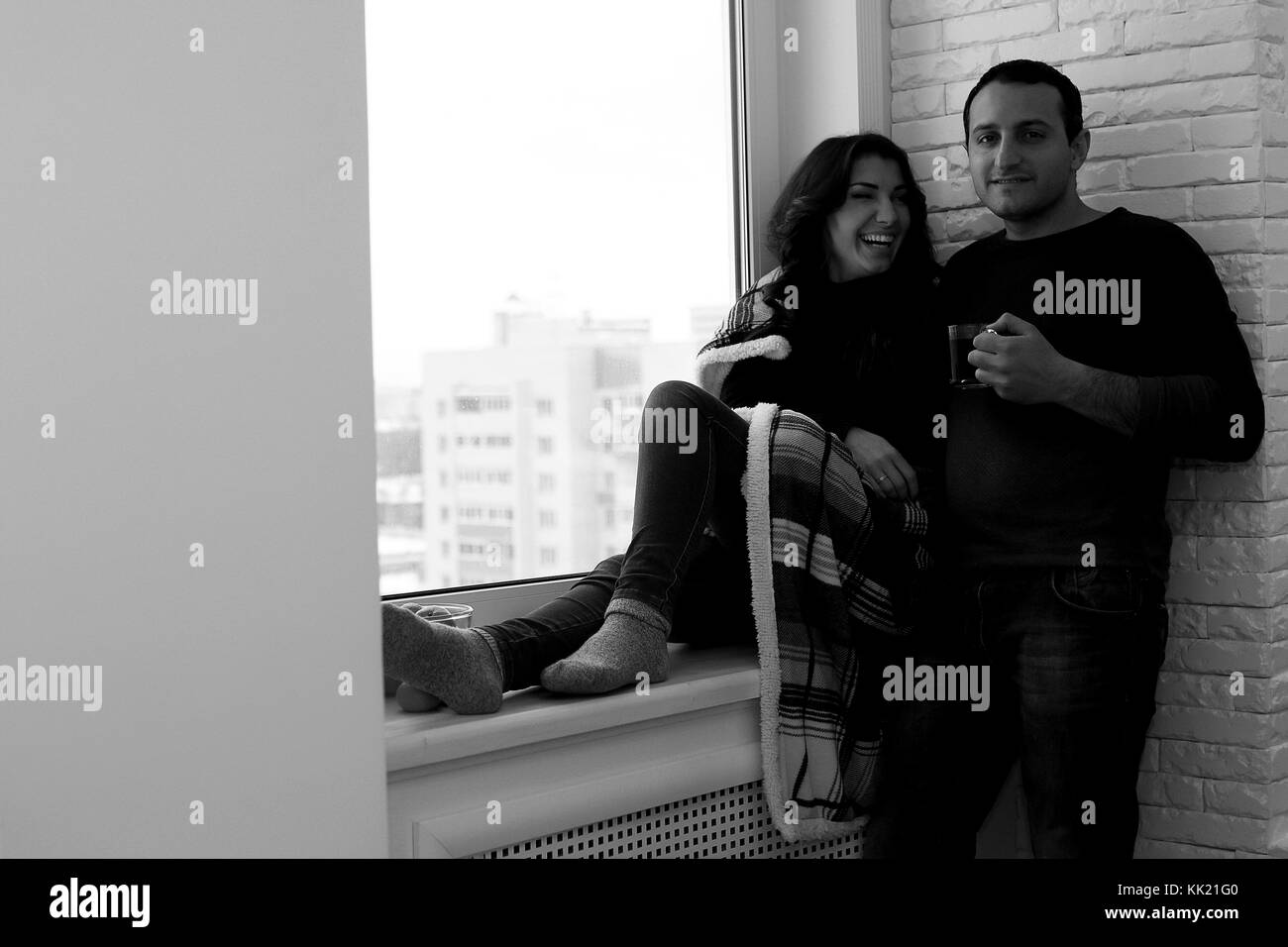 Couple in front of a window Stock Photo - Alamy
