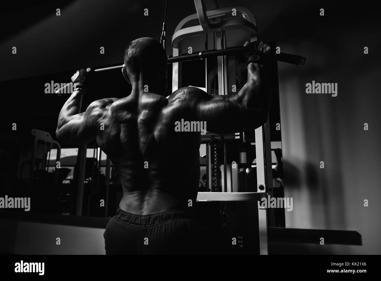 Handsome Bodybuilder Doing Heavy Weight Exercise For Back On Machine ...