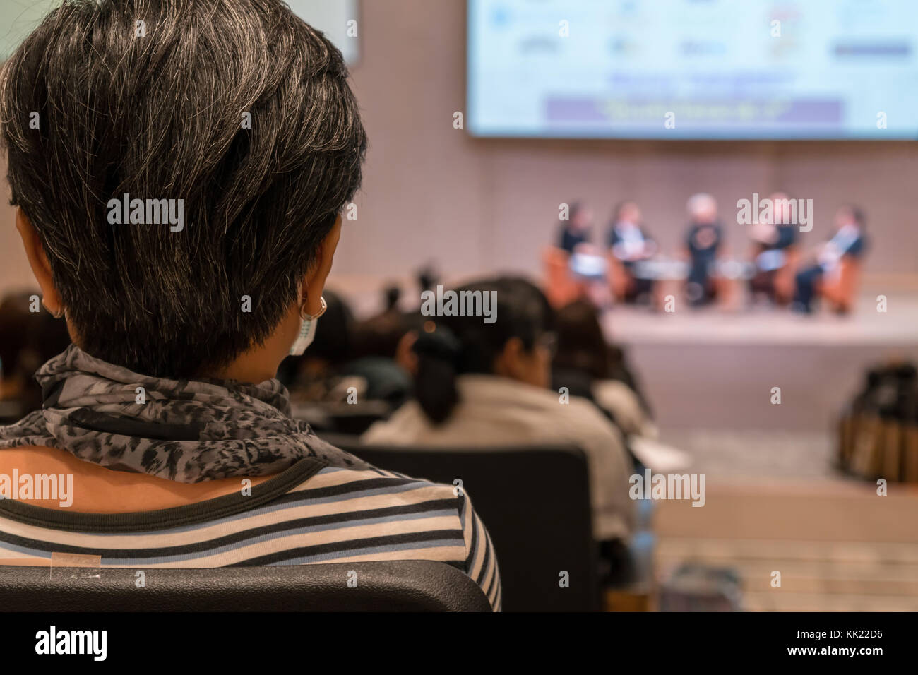 Rear view of Audience over the speakers on the stage in the conference ...