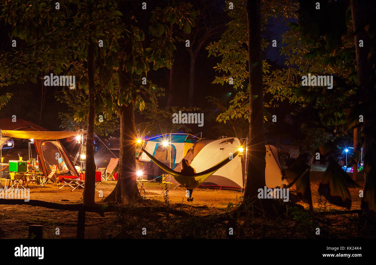 Amazing scene in night camping -girl in hammock on tents background ...